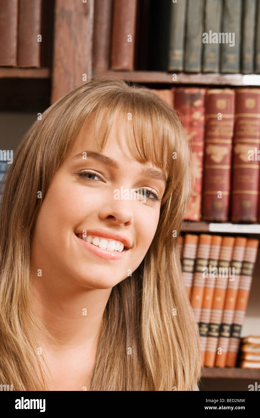 Portrait of a woman smiling in a library Stock Photo - Alamy