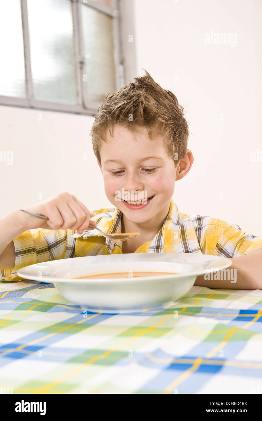 Boy happily eating a bowl of soup Stock Photo - Alamy