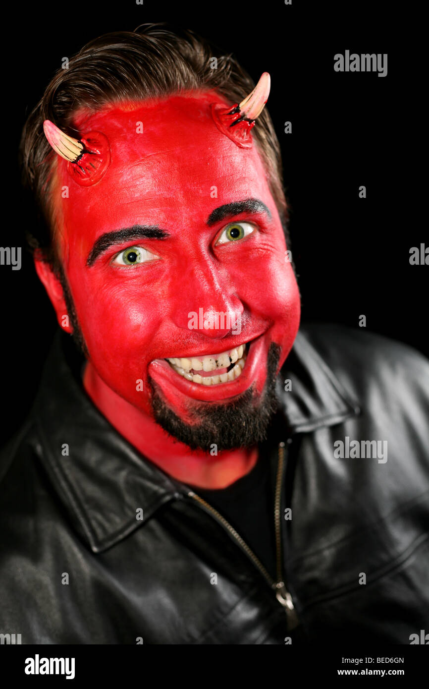 Devilish man with red skin, horns, and maniacal smile Stock Photo - Alamy