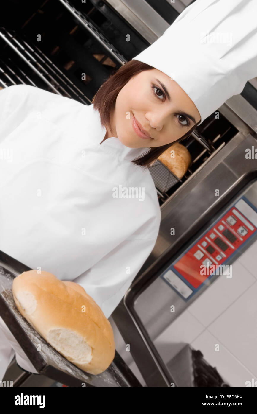 Female chef holding a bun in a tray Stock Photo - Alamy