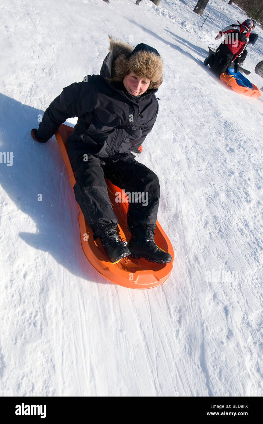 women smiling while sliding down hill in the snow Stock Photo - Alamy