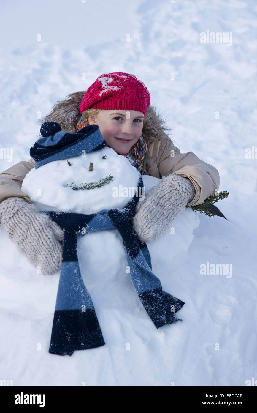 Girl hugging a snowman, smiling Stock Photo - Alamy