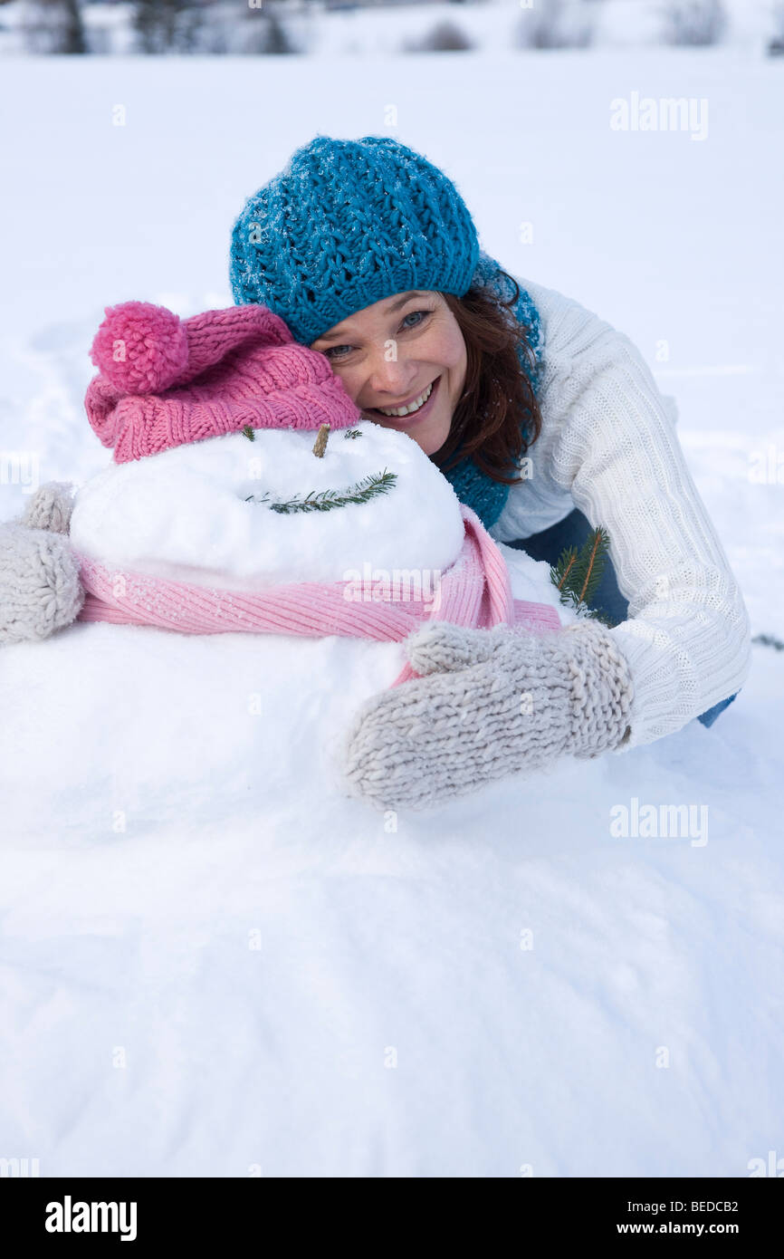 Woman hugging a snowman, smiling Stock Photo - Alamy