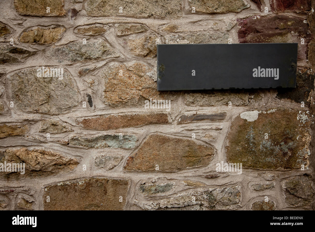 Blank slate sign mounted on stone wall Stock Photo - Alamy