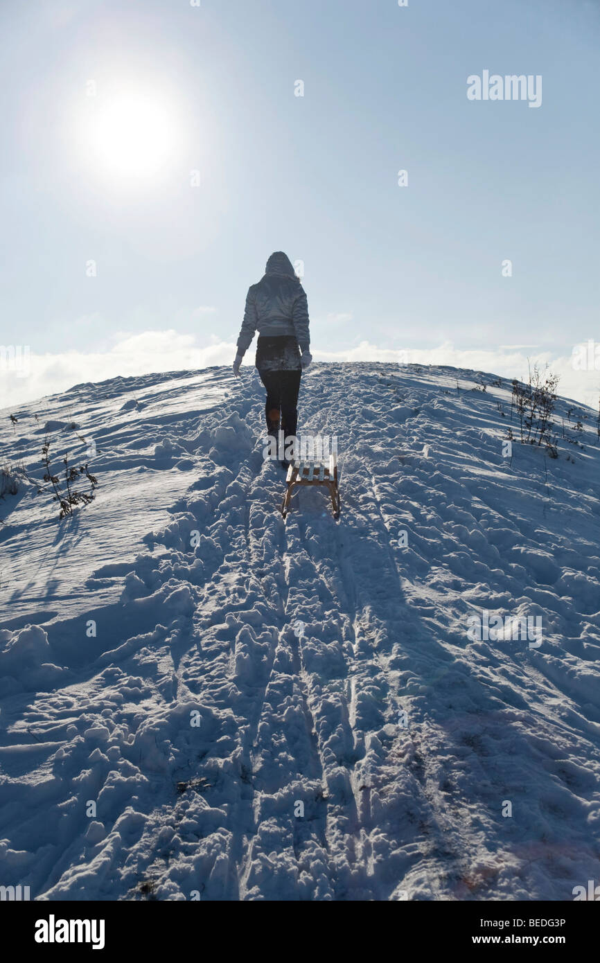 Young woman pulling a sledge in the snow Stock Photo - Alamy