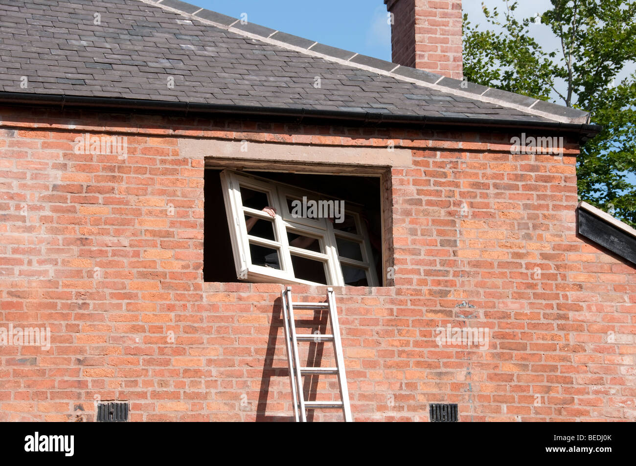 Fitting new window frame into an old cottage Stock Photo - Alamy