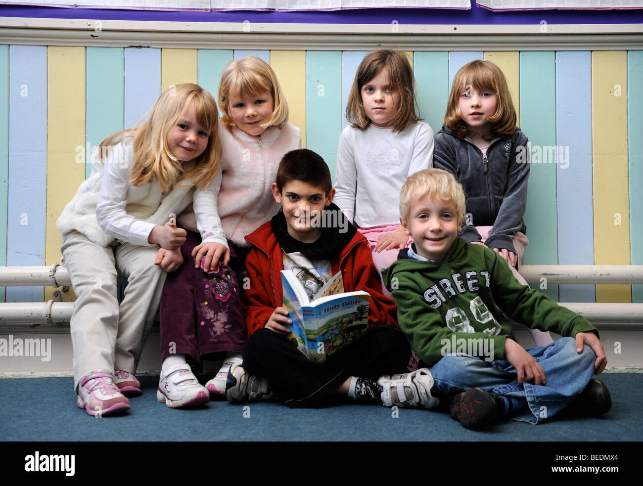 A GROUP OF FOUR GIRLS AND TWO BOYS READING A BIBLE TOGETHER AT A SUNDAY ...