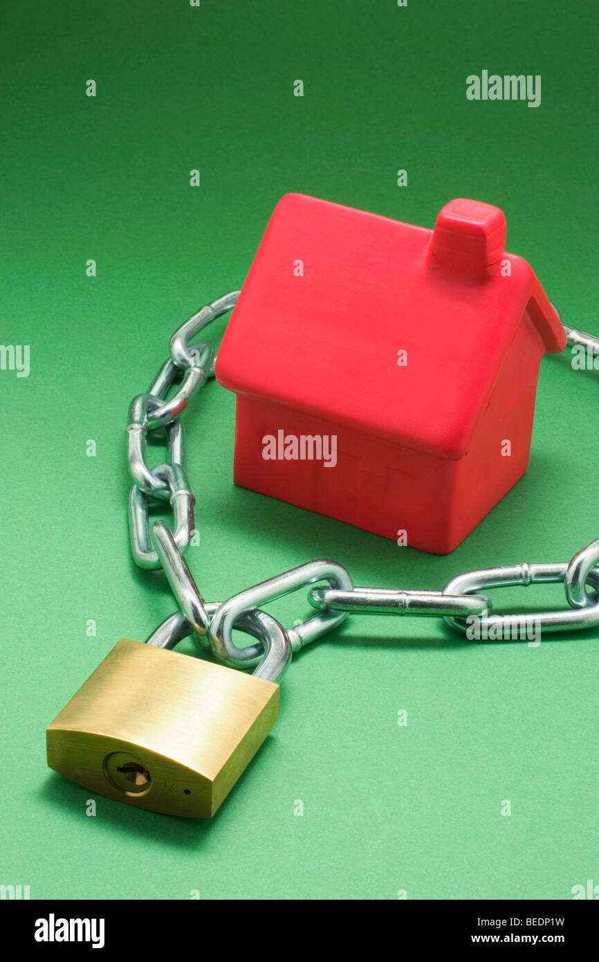 Miniature house with lock and chain Stock Photo - Alamy
