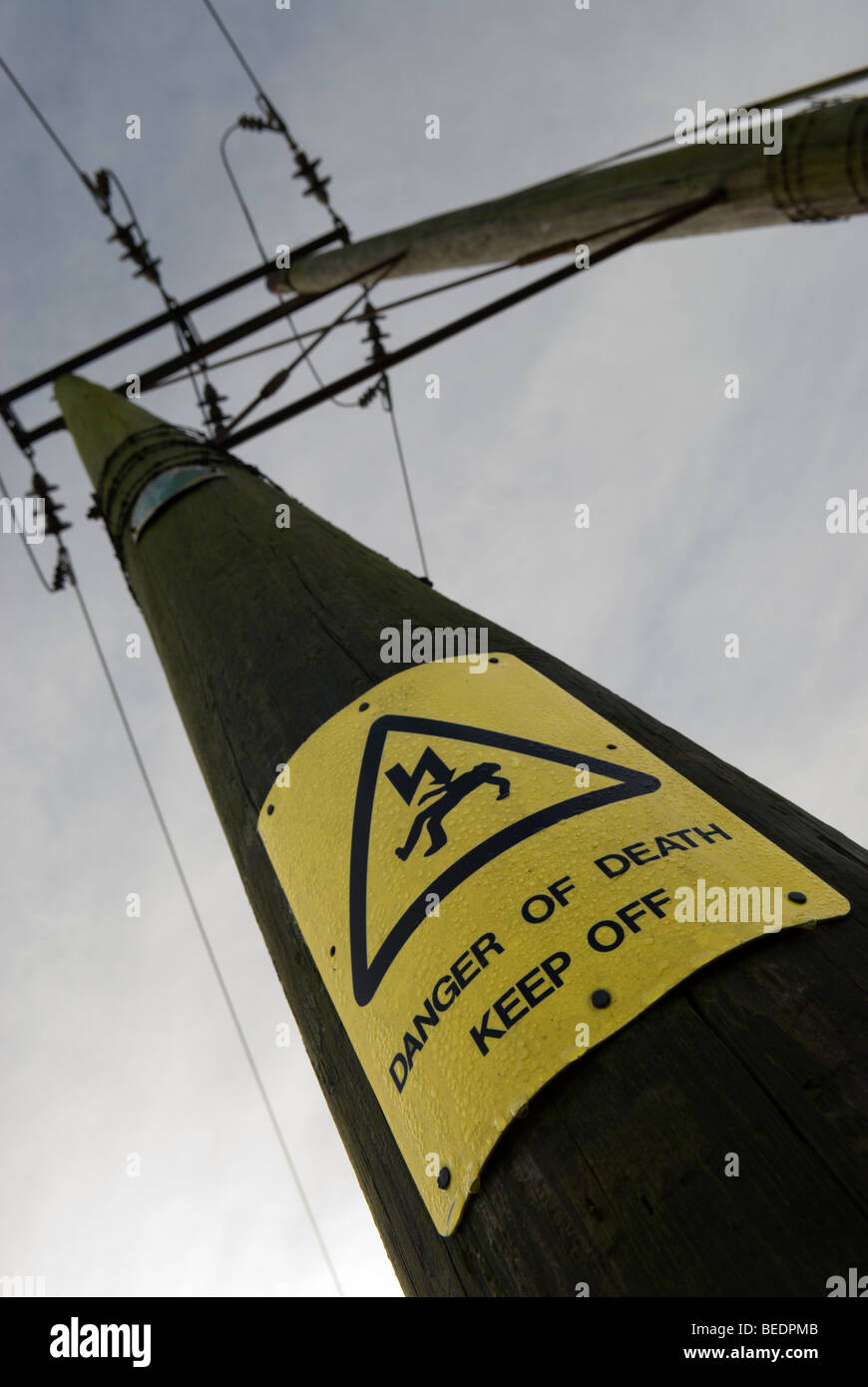 Danger signs on poles carrying electrical power lines Stock Photo - Alamy