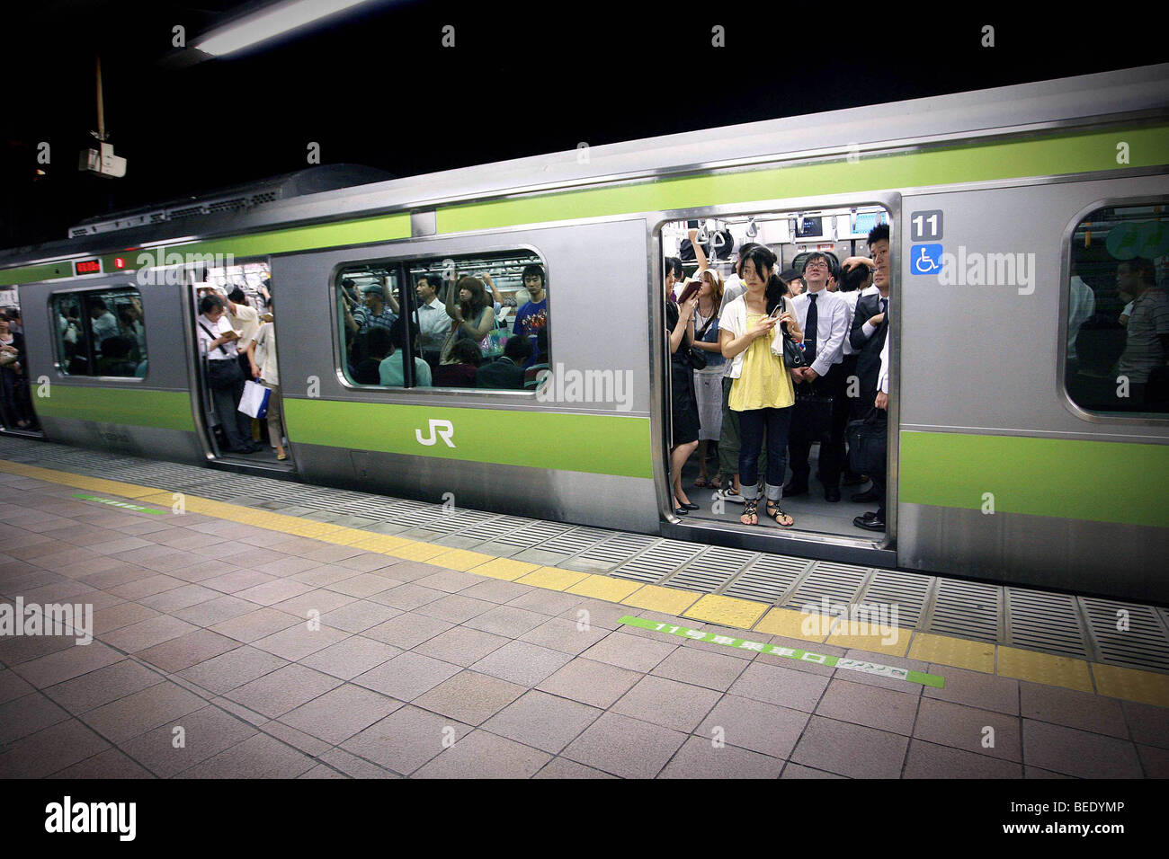 Passengers squeeze into a busy subway train in downtown Tokyo, Japan ...