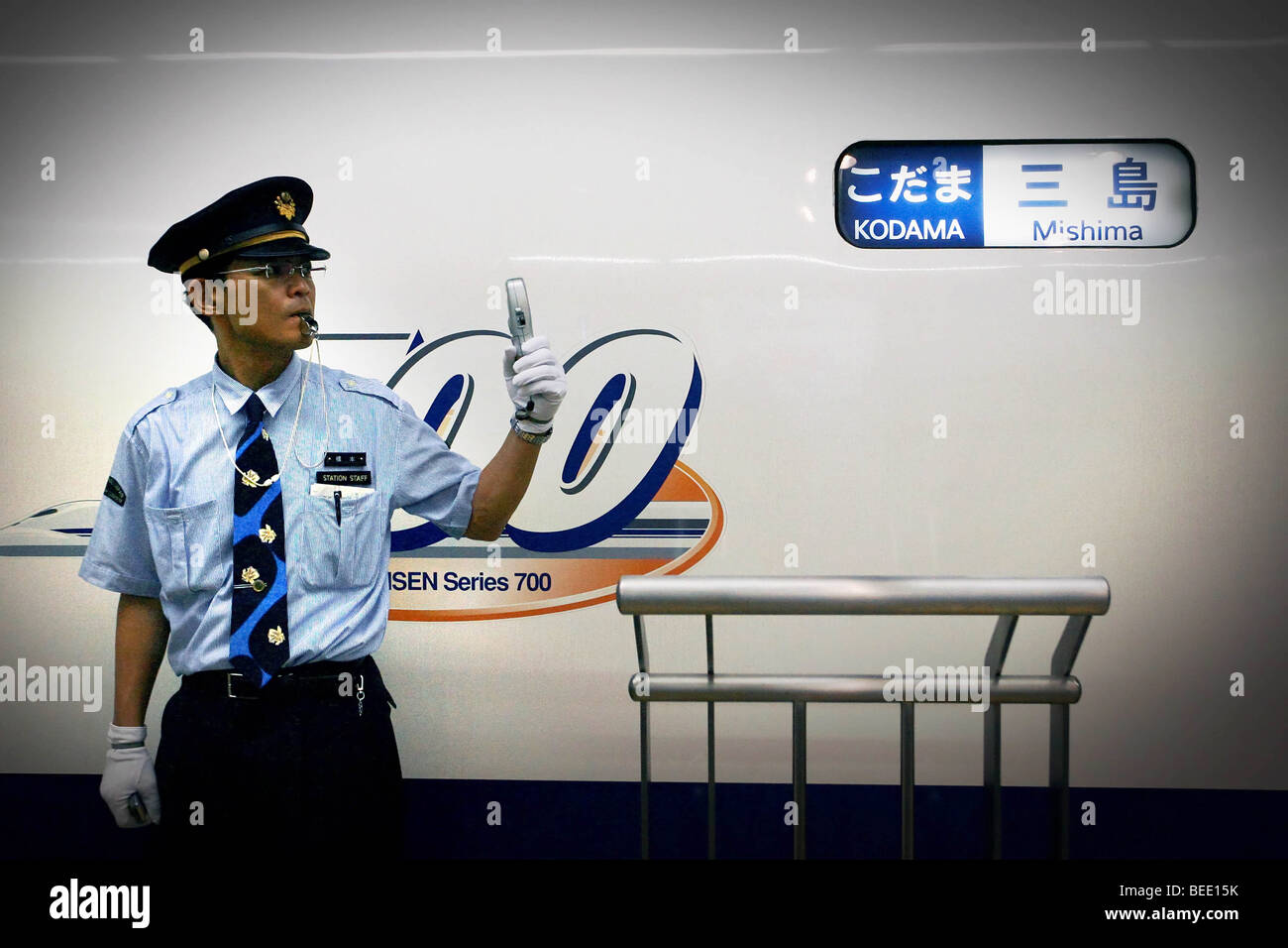 A train conductor signals to colleagues infront of a Kodama class high ...