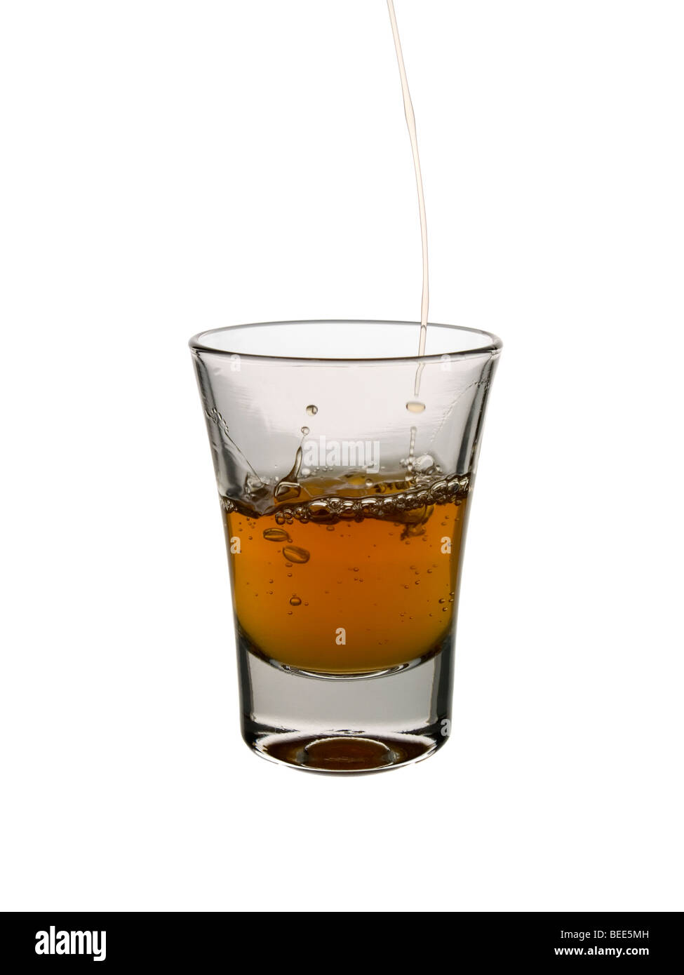 Pouring a shot of whiskey on white background Stock Photo - Alamy