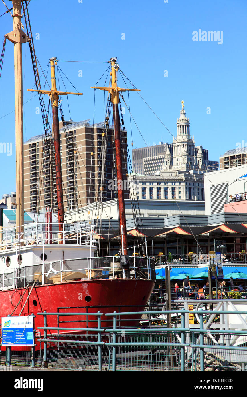 Old sailing ships with tall masts in front of modern skyscraper ...