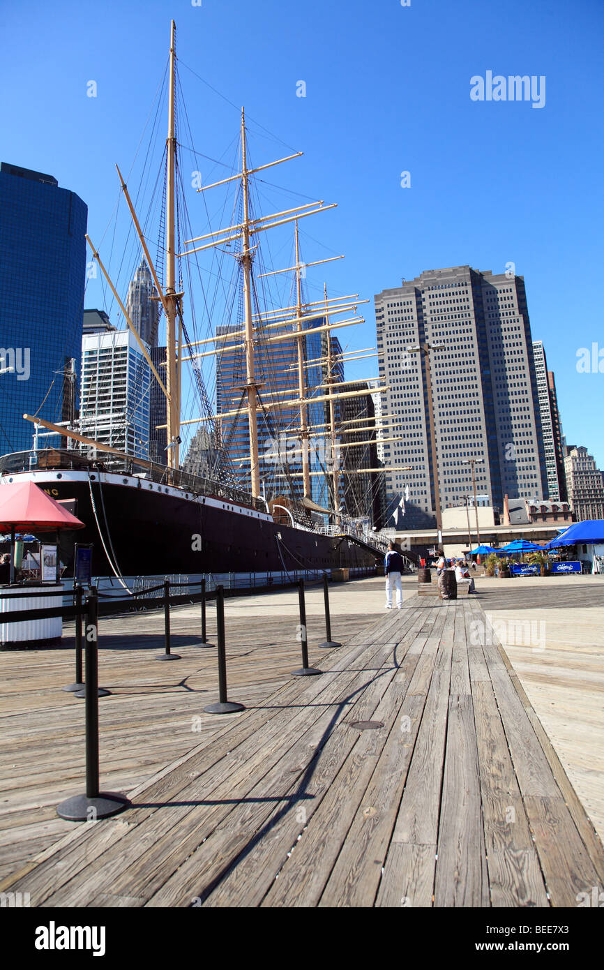 Old sailing ships with tall masts in front of modern skyscraper ...