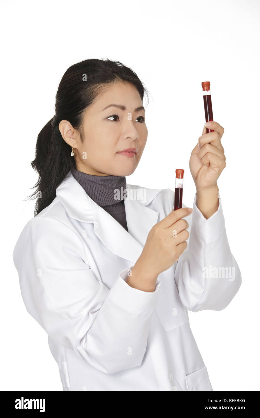 Beautiful Asian laboratory technician examining a tube of blood Stock ...
