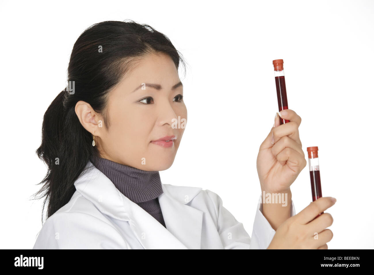 Beautiful Asian laboratory technician examining a tube of blood Stock ...