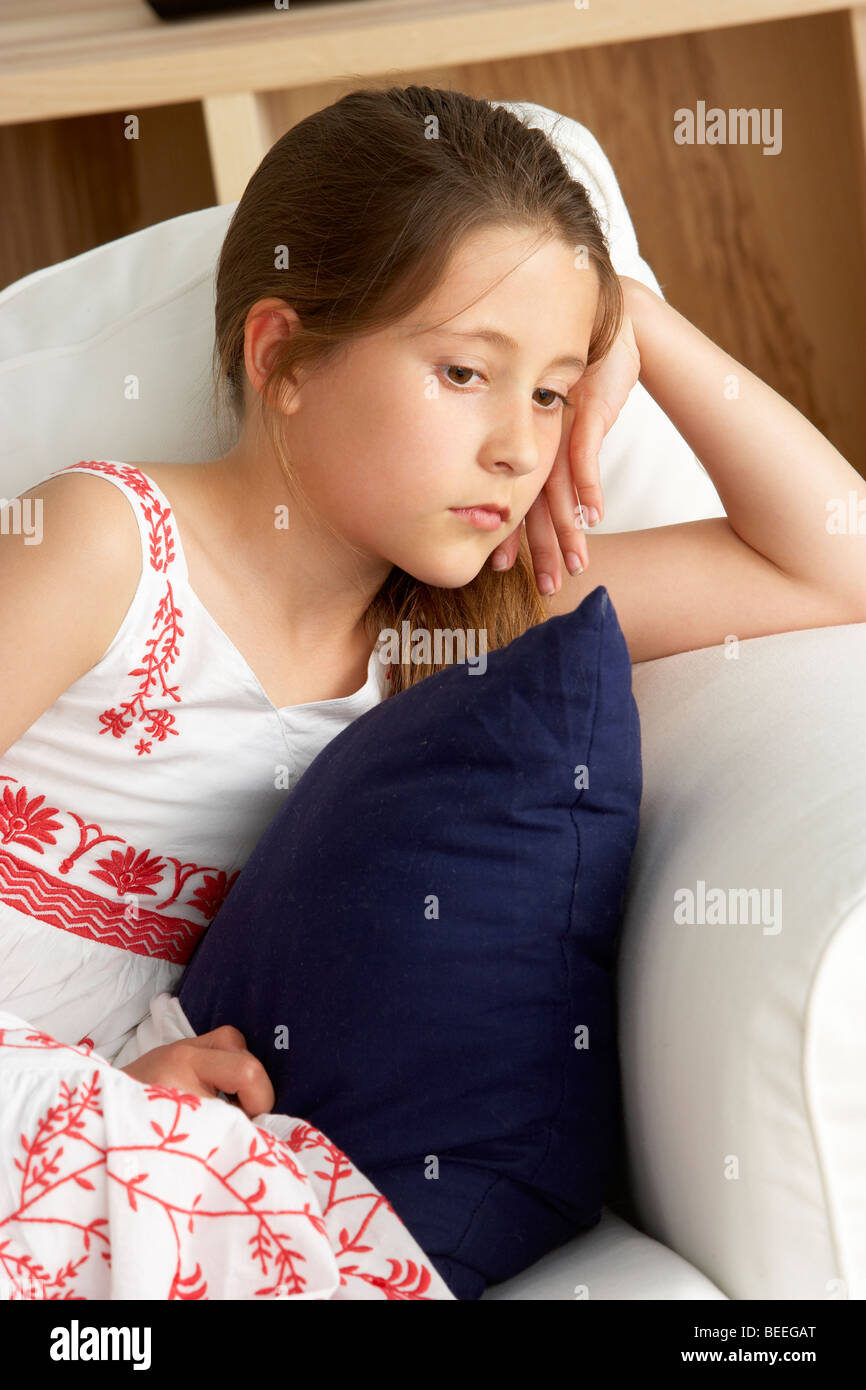 Young Girl Sat on Sofa at Home Stock Photo - Alamy