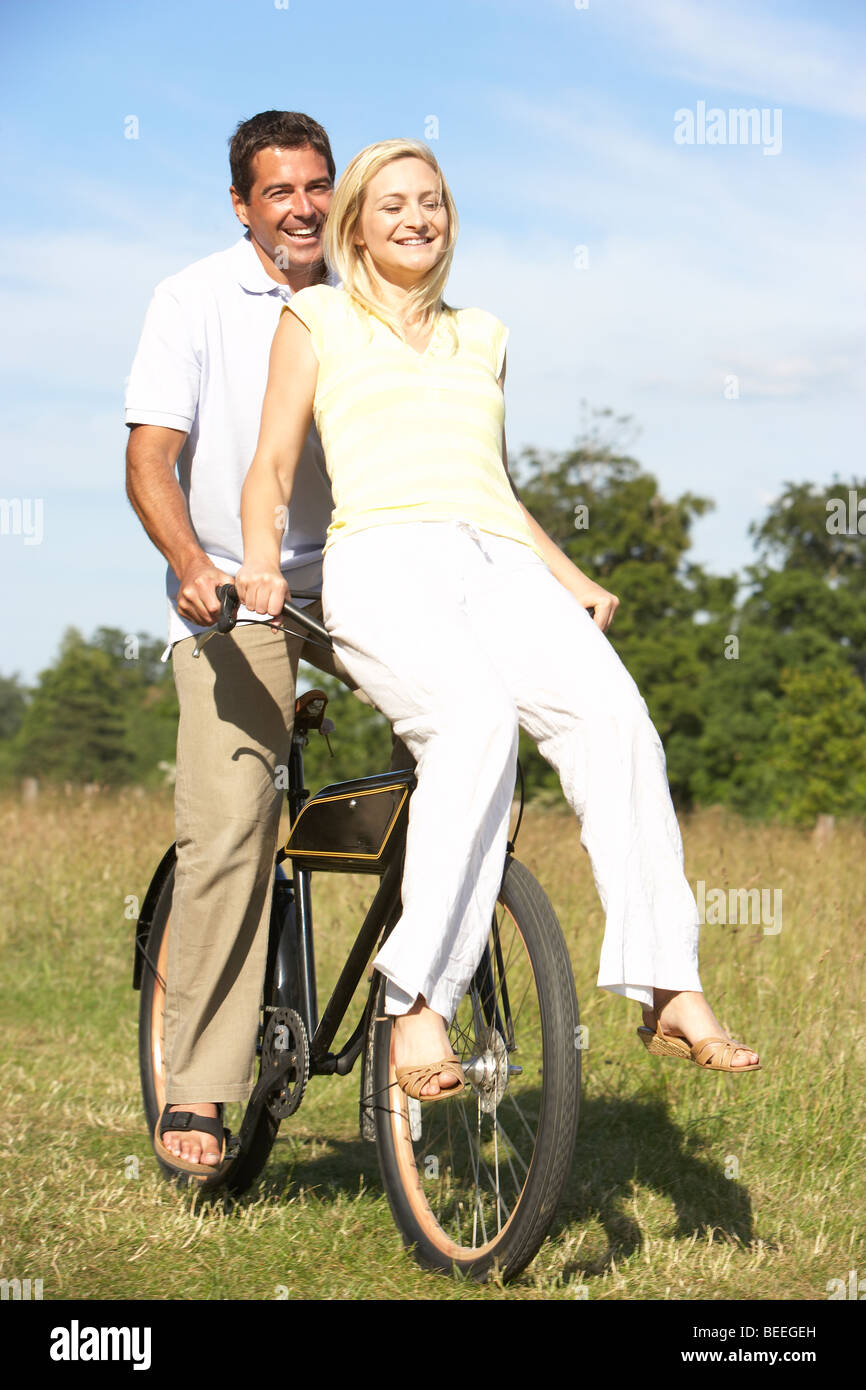 Young couple riding bike in countryside Stock Photo - Alamy