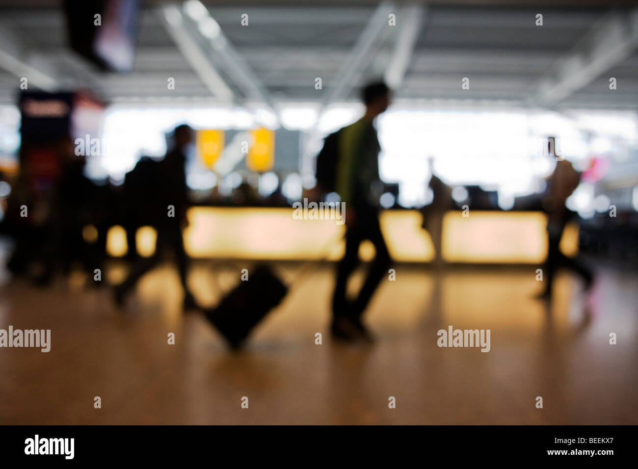 Out of focus, anonymous passengers pass-by against strong back light in ...