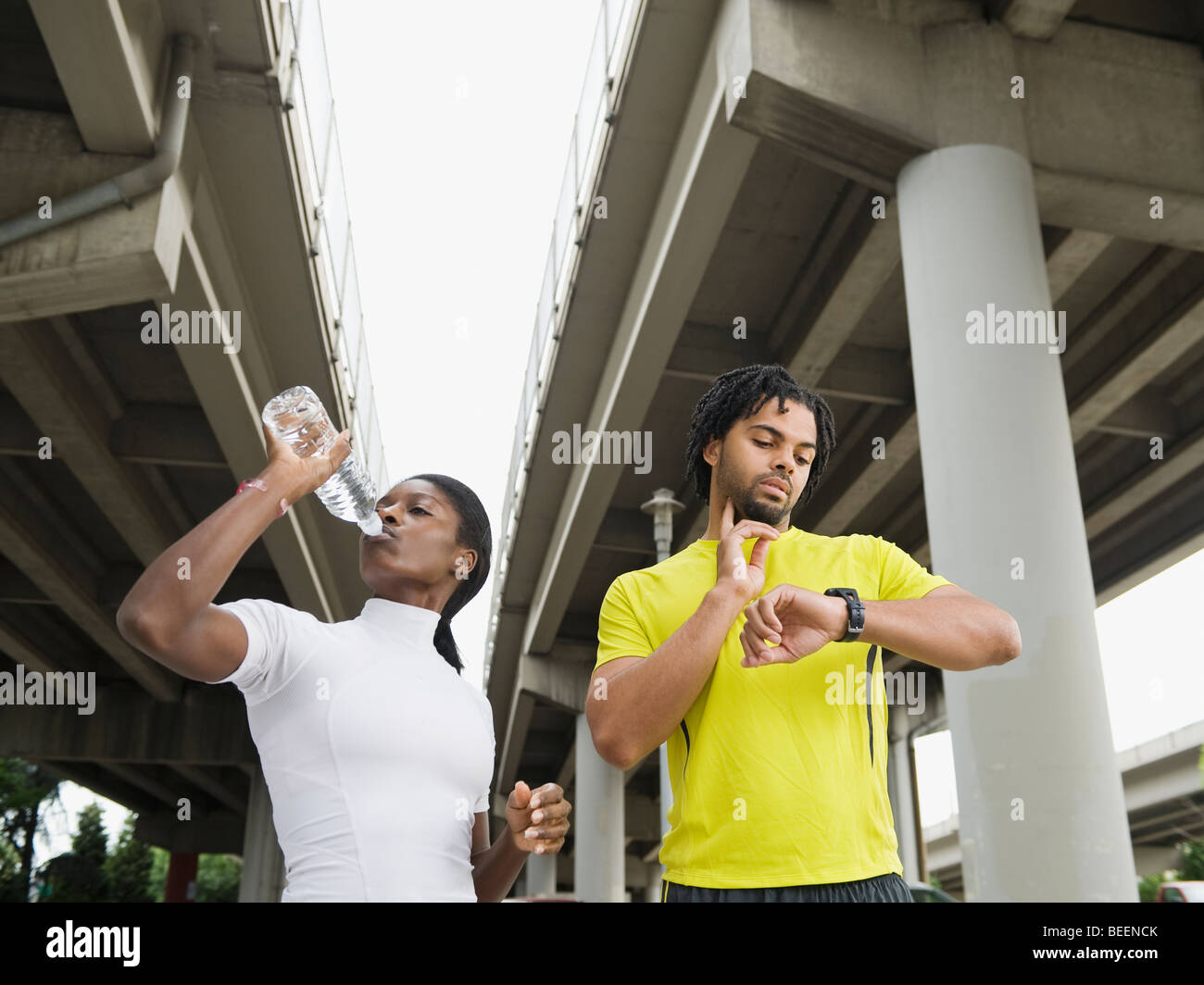 Runners taking a break under freeway overpass Stock Photo - Alamy