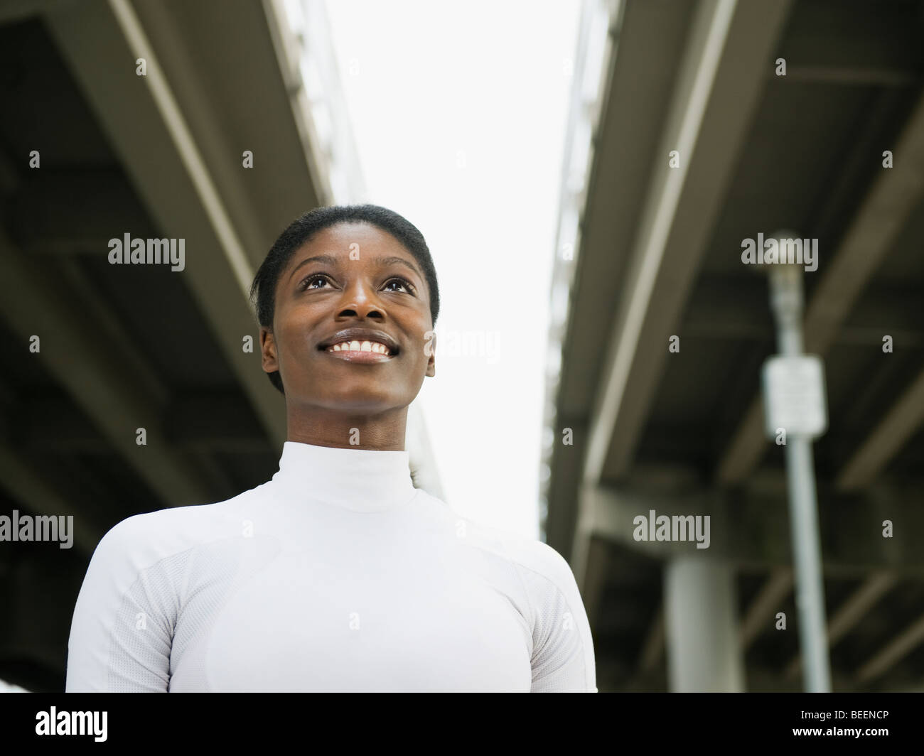 African woman smiling under freeway overpass Stock Photo - Alamy