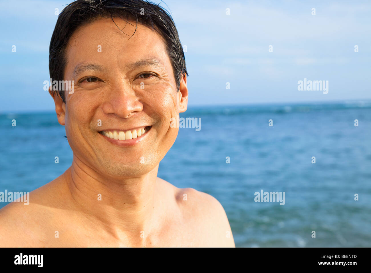 Japanese man smiling on beach Stock Photo - Alamy
