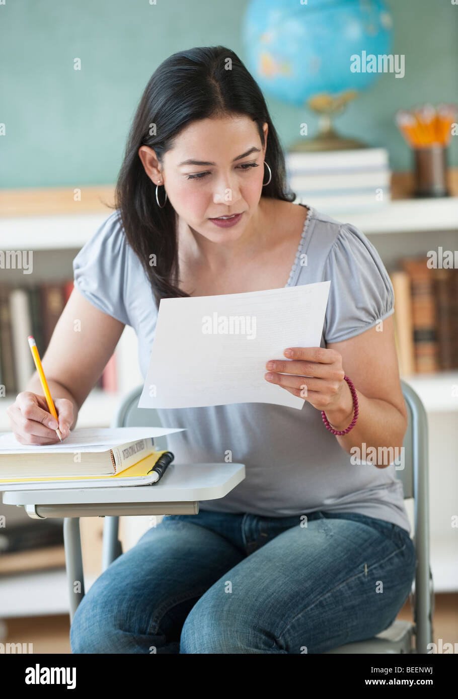 Hispanic woman doing homework in classroom Stock Photo - Alamy