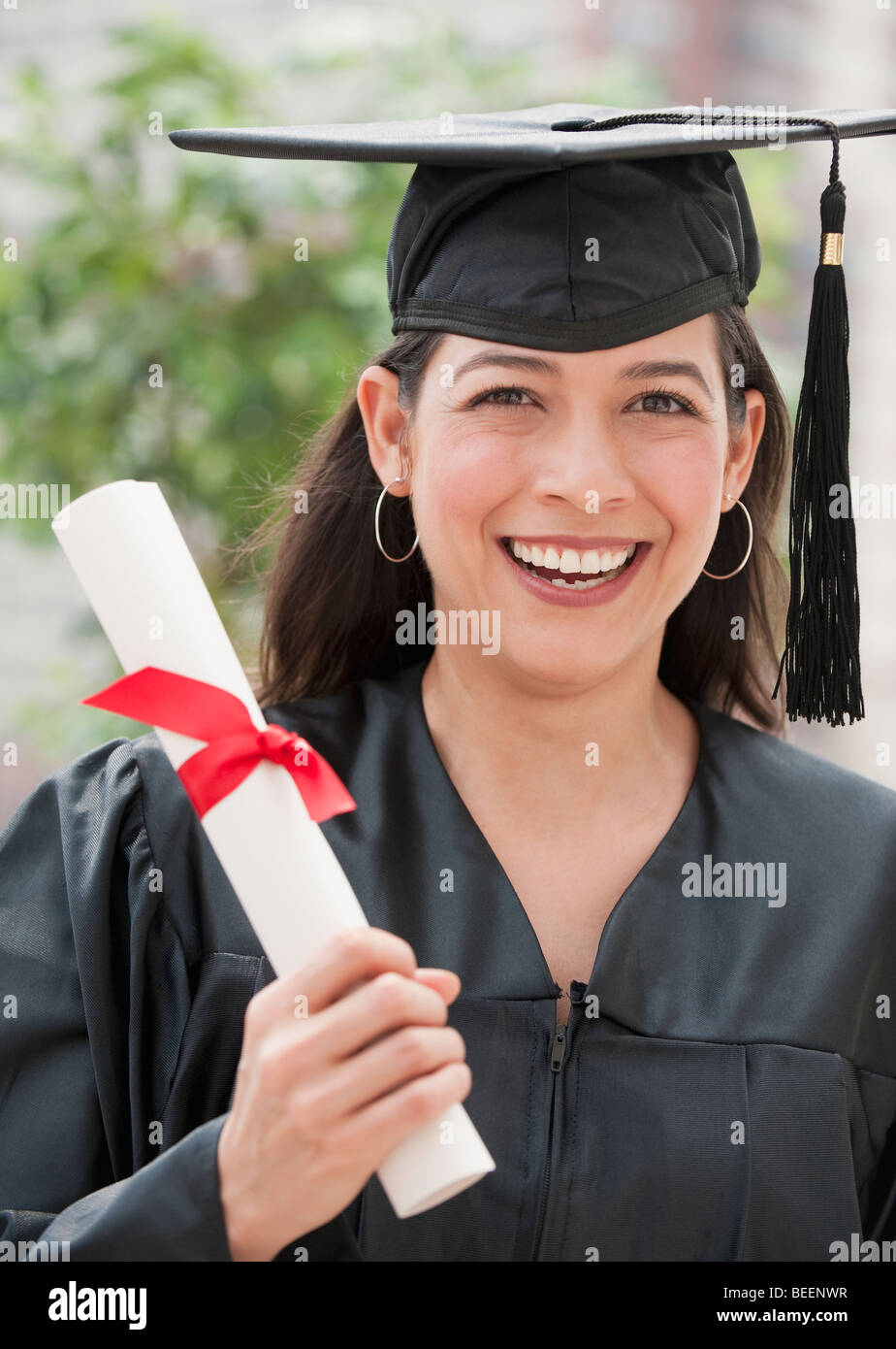 Hispanic graduate holding diploma Stock Photo - Alamy