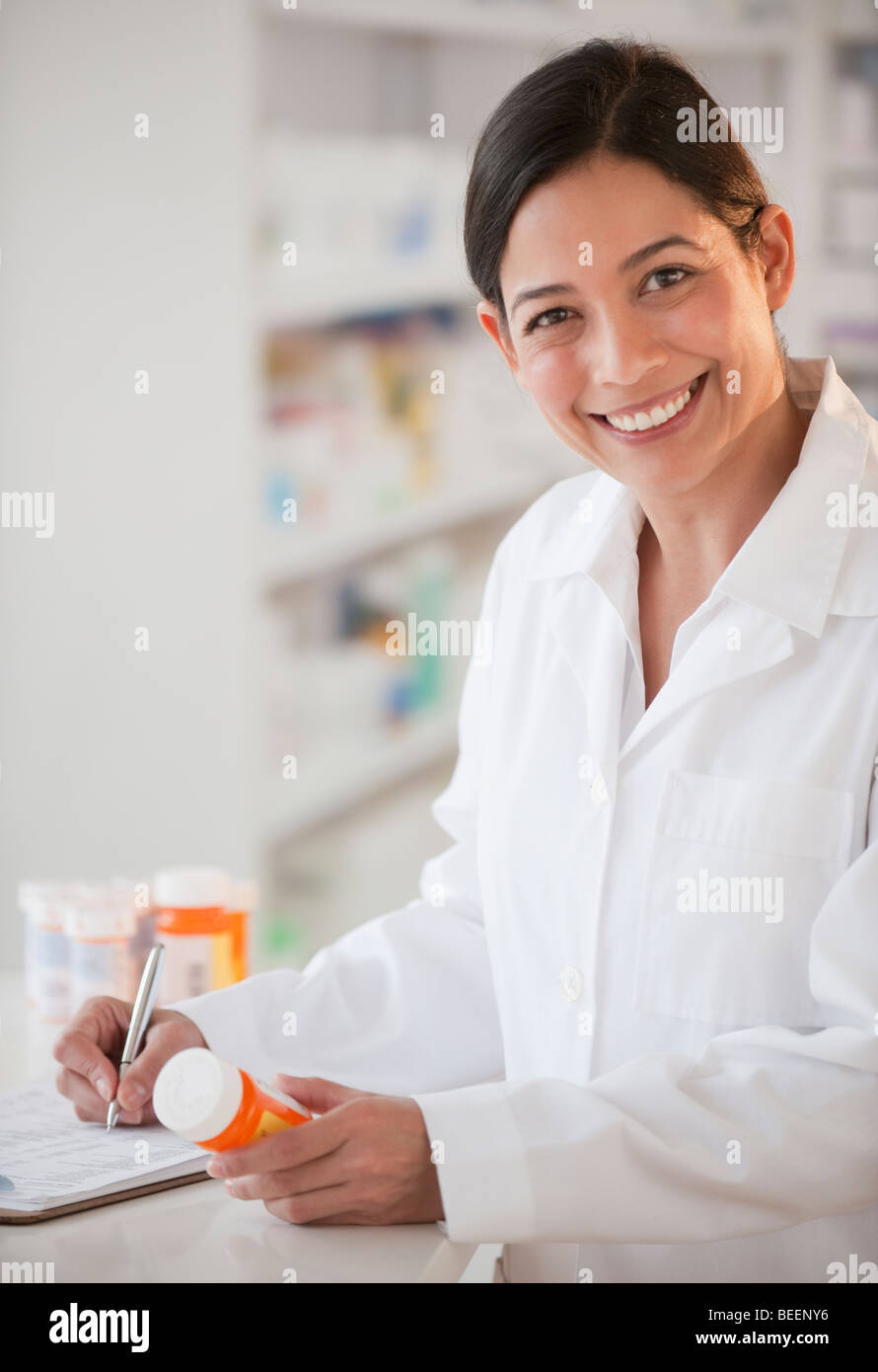 Hispanic pharmacist holding prescription bottle Stock Photo - Alamy
