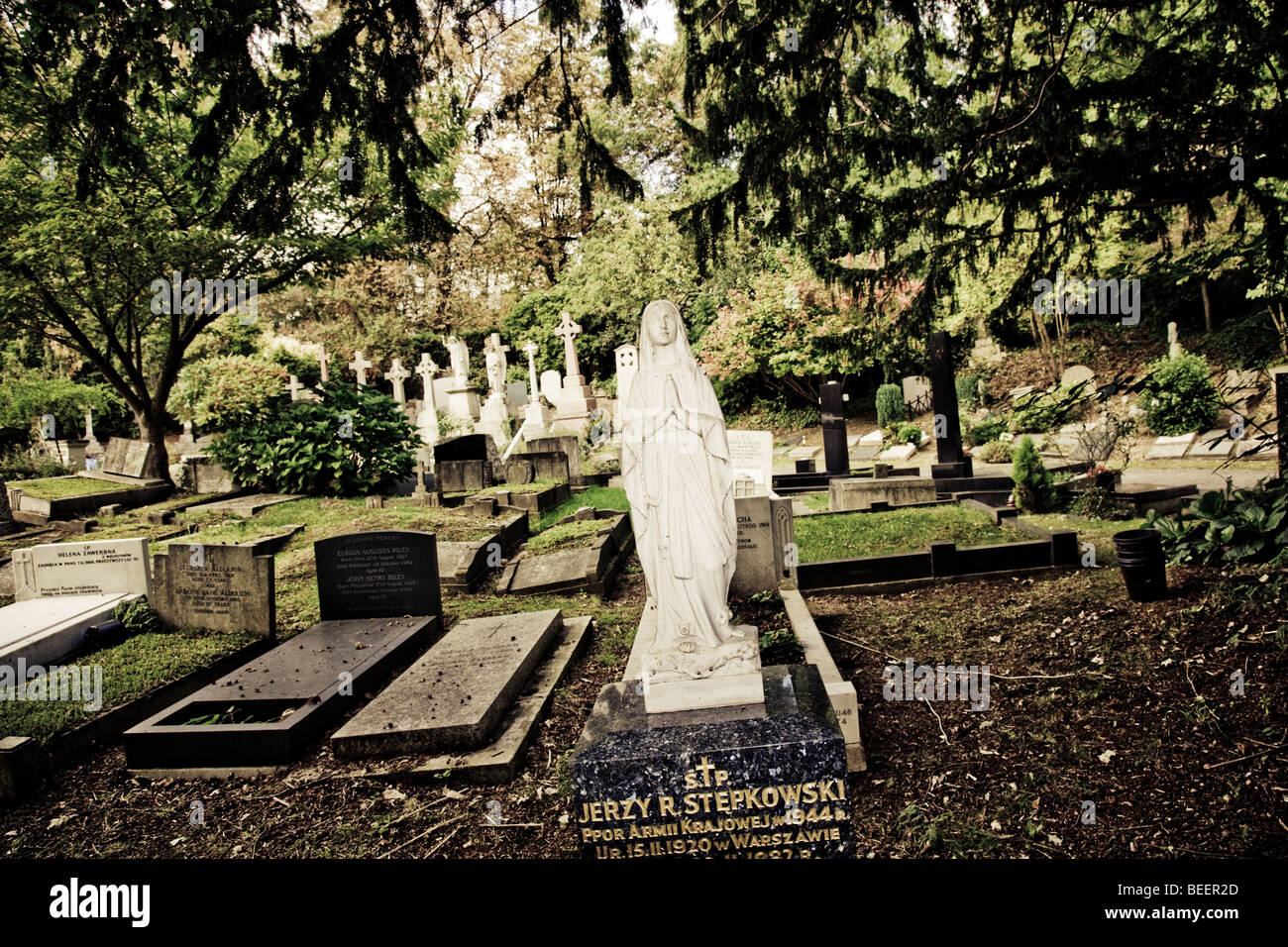 A praying female figure made of stone stands over a black marble grave ...