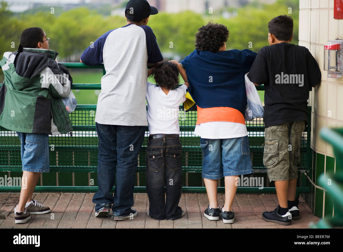Boys leaning against railing Stock Photo - Alamy