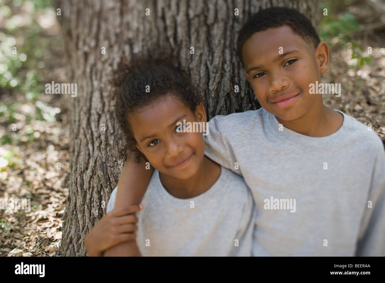 African boy and girl hugging against tree Stock Photo - Alamy