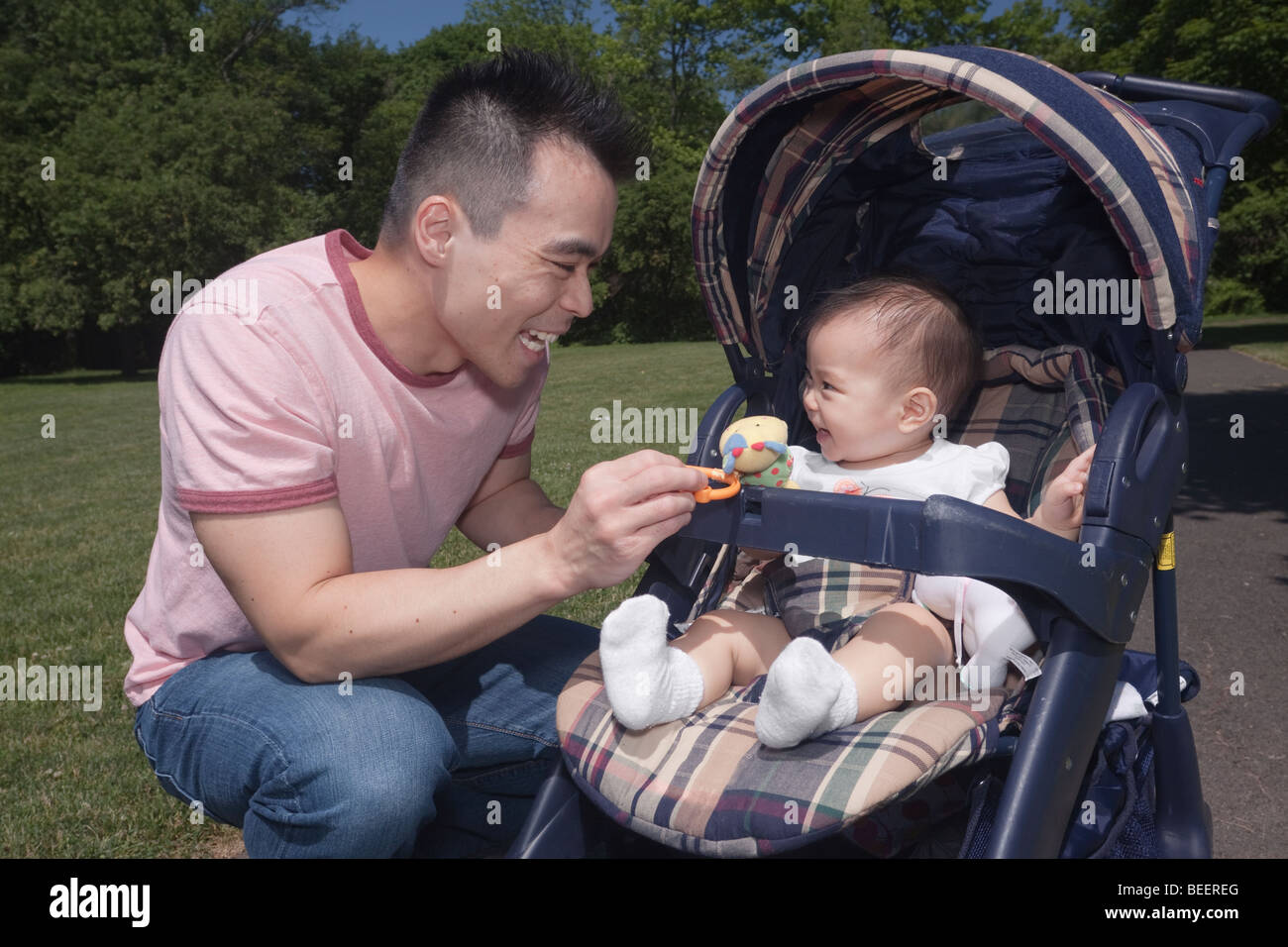 Chinese father and baby in stroller at park Stock Photo - Alamy