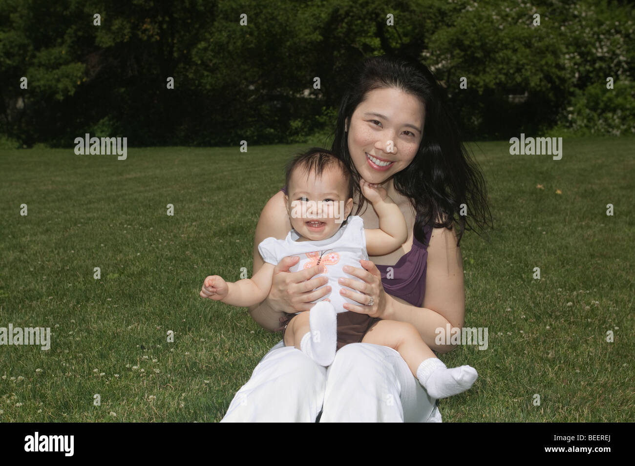 Chinese mother holding baby in park Stock Photo - Alamy