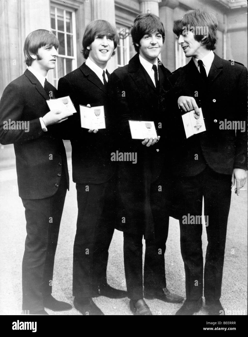 The Beatles hold up their M.B.E awards Stock Photo - Alamy