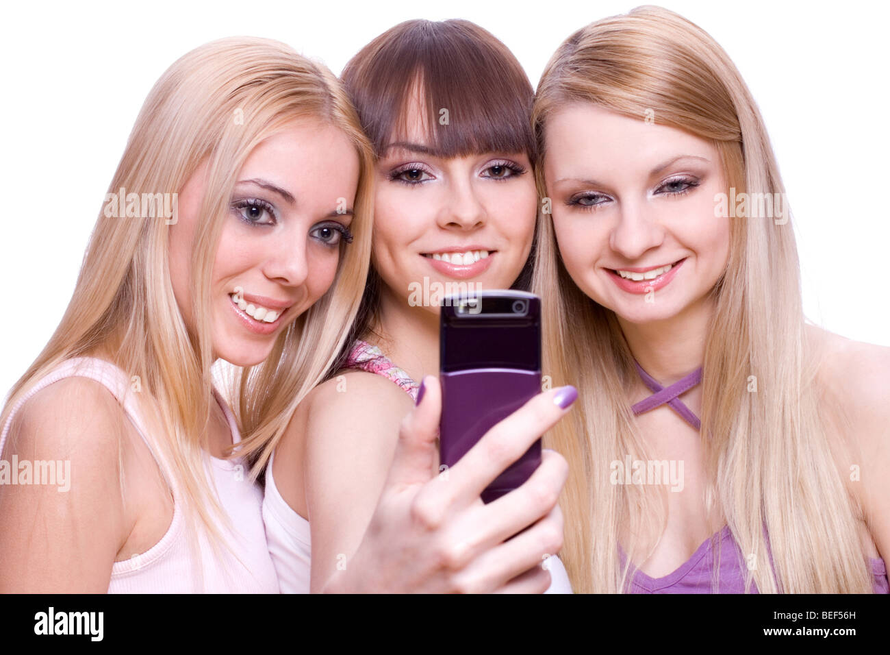 three girls with phone on a white background Stock Photo - Alamy