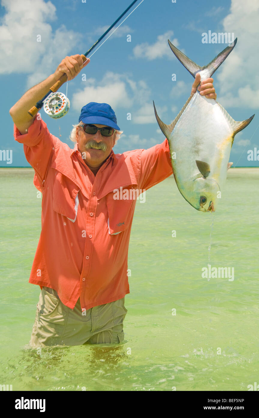 Florida, Florida Keys, Mature Fisherman holding up trophy sport fish ...