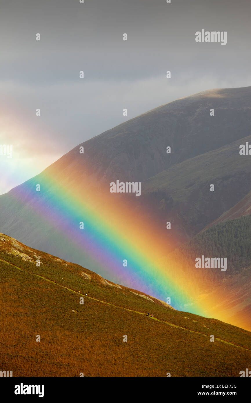 A rainbow arches over Steel Fell and walkers in the Lake District, UK ...