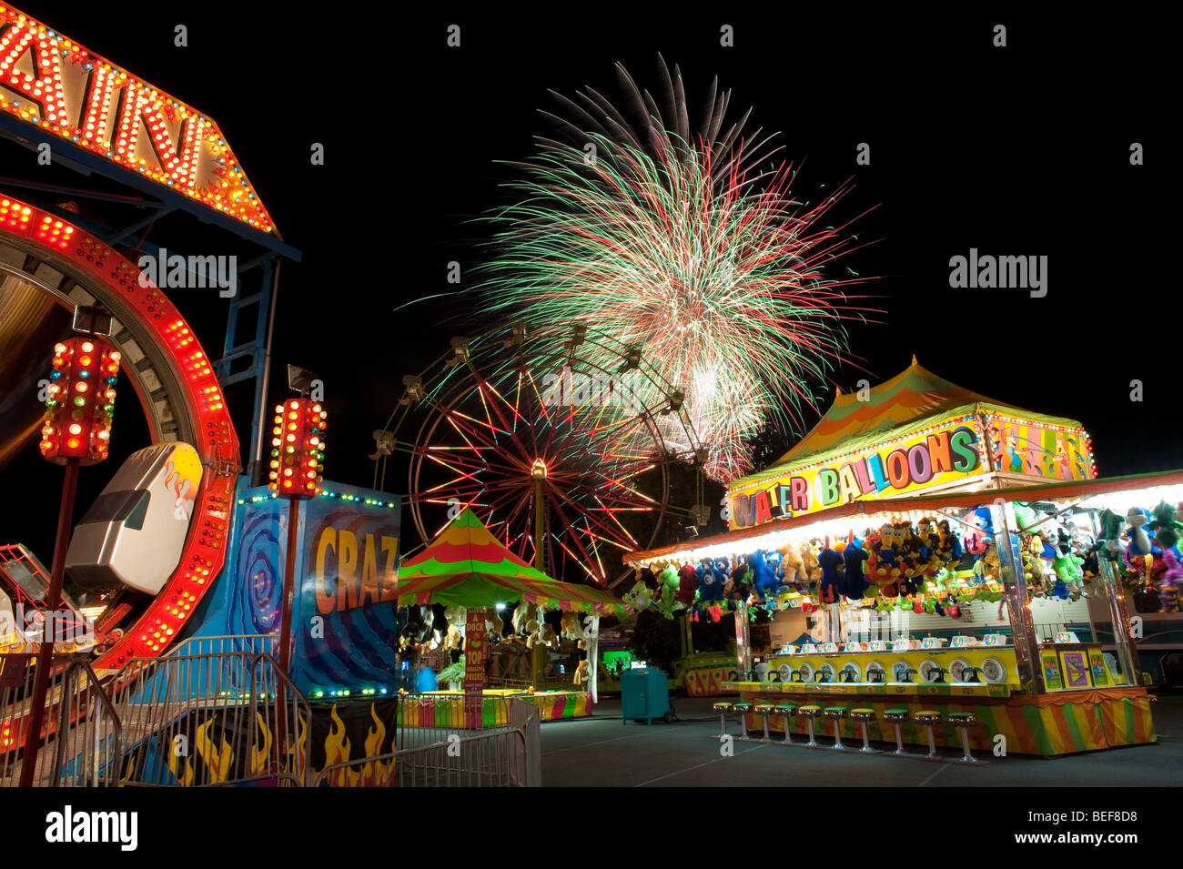 Evergreen State Fair with amusement rides and game booths at night with ...