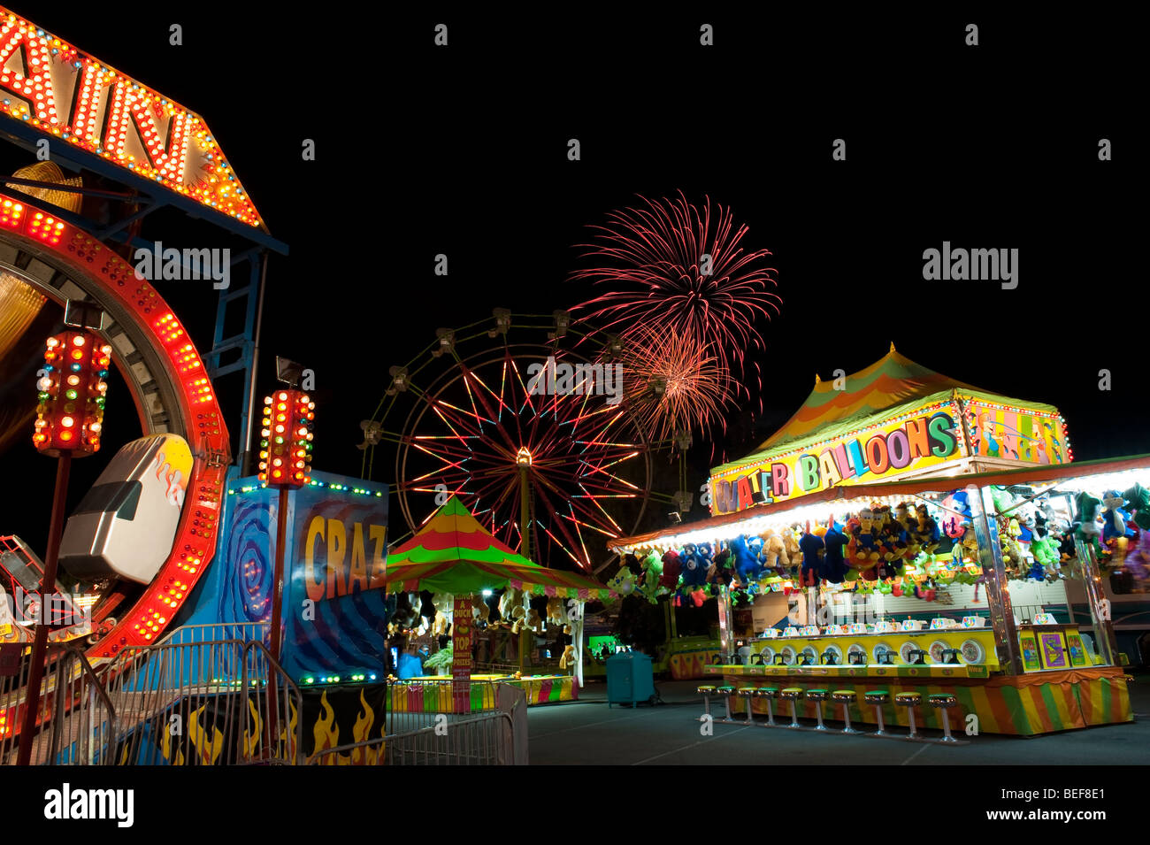 Evergreen State Fair with amusement rides and game booths at night with ...