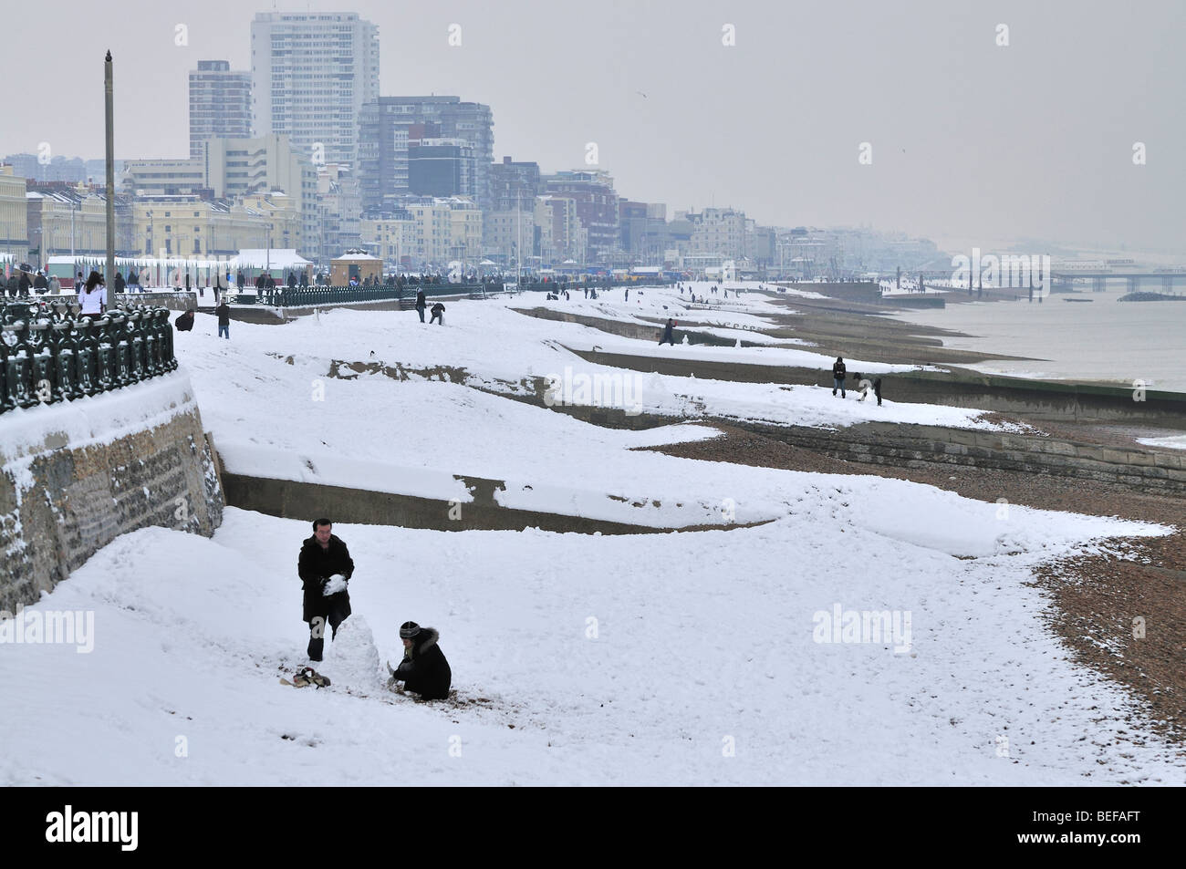 Snow Beach Hove people playing Stock Photo - Alamy
