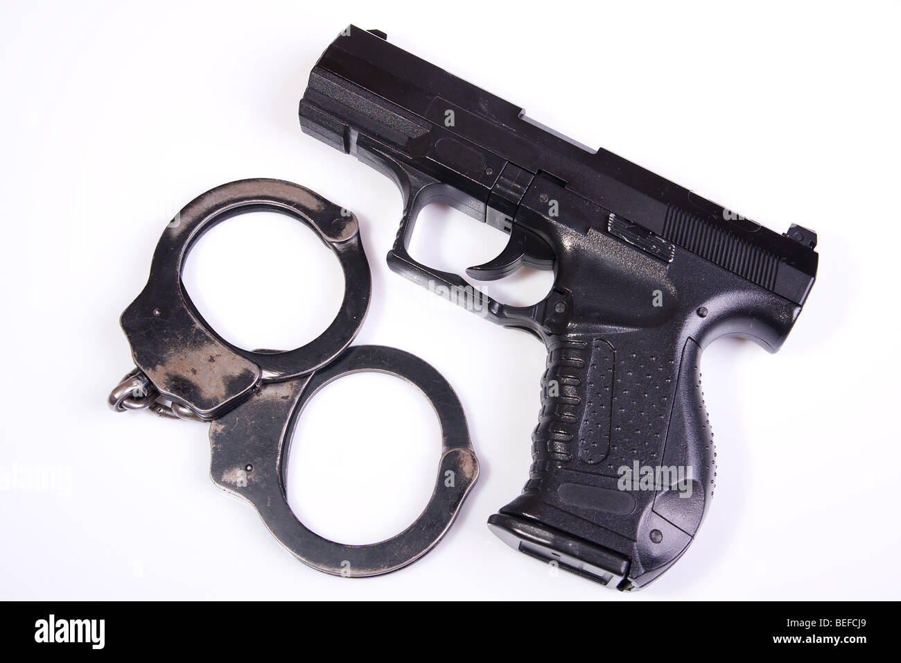 gun and cuffs isolated on white background Stock Photo - Alamy