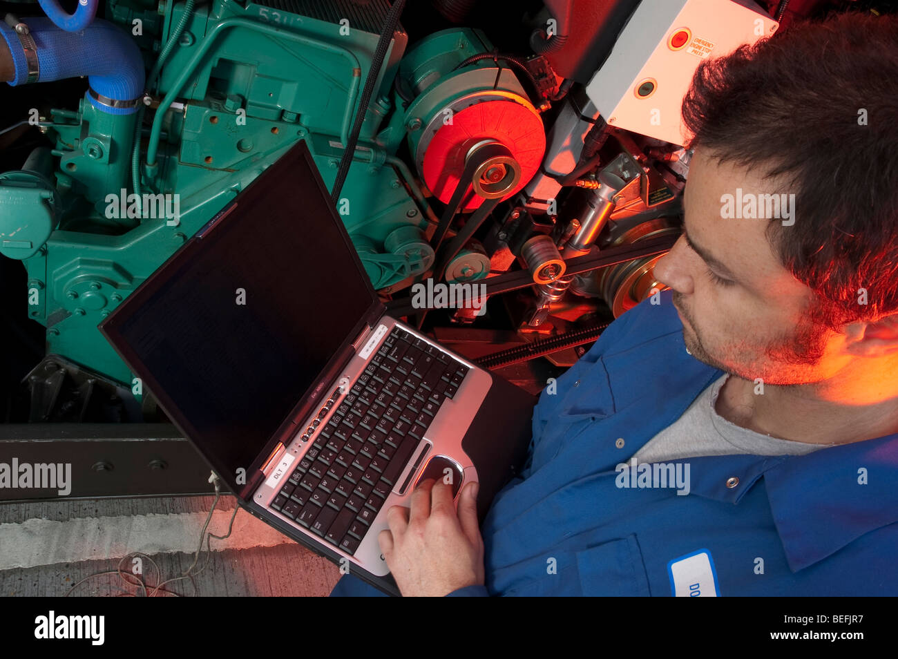 Motor mechanic using computer to set up and diagnose a coach engine ...