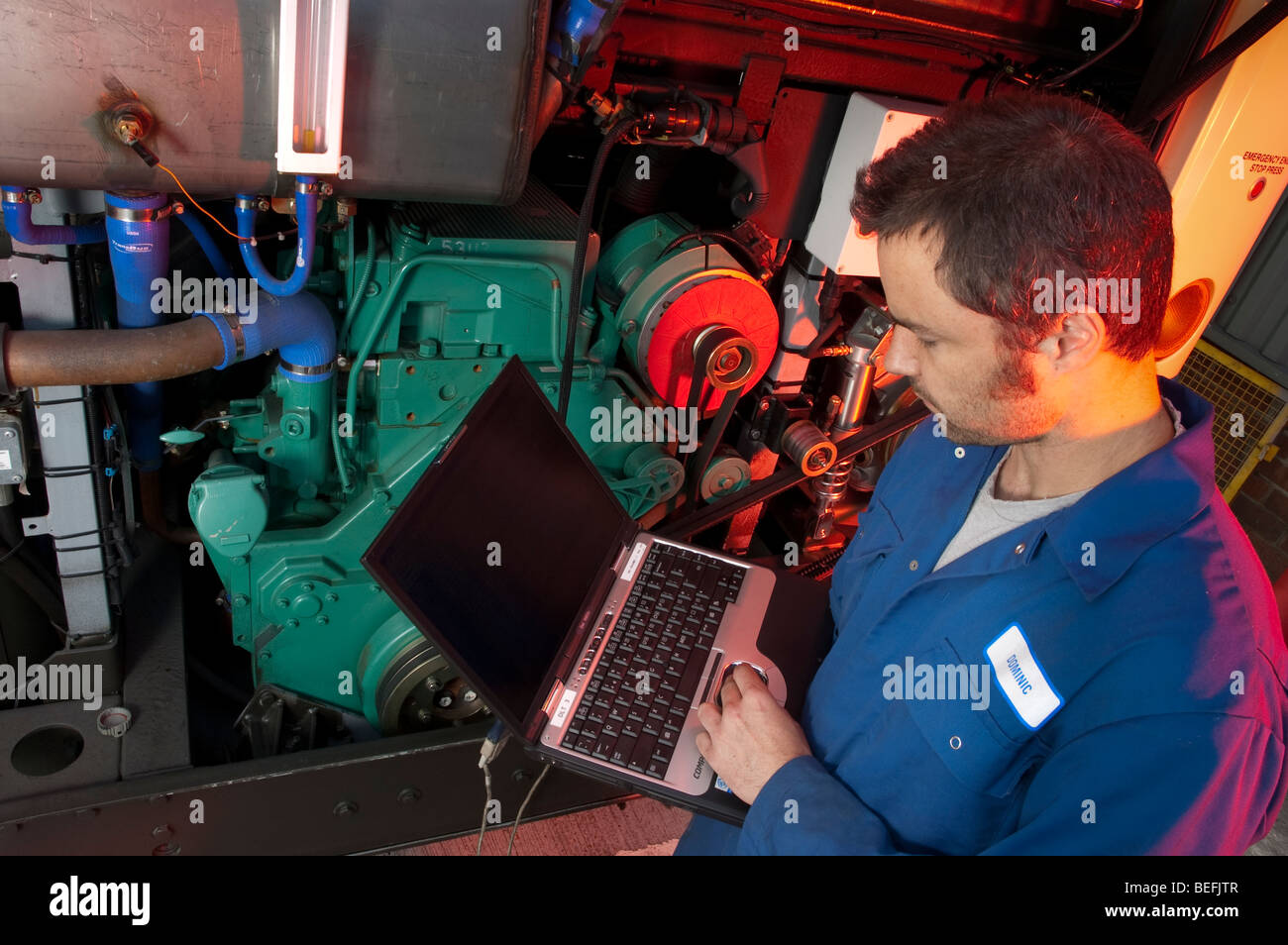 Motor mechanic using computer to set up and diagnose a coach engine ...