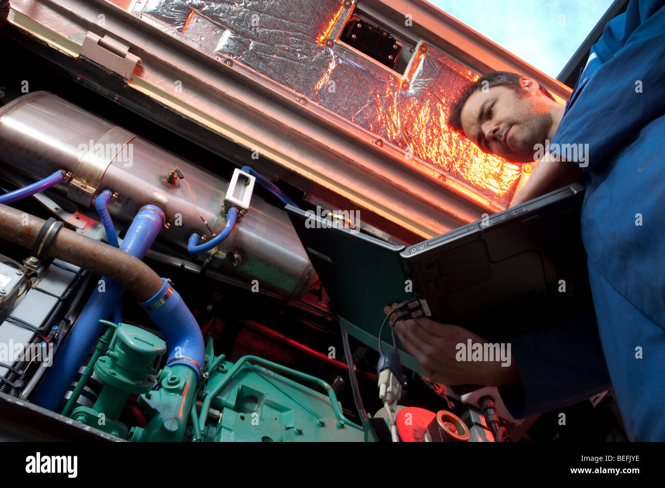 Motor mechanic using computer to set up and diagnose a coach engine ...