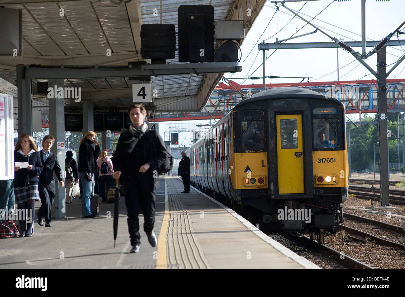 Class 317 train and passengers at Cambridge railway station, England ...