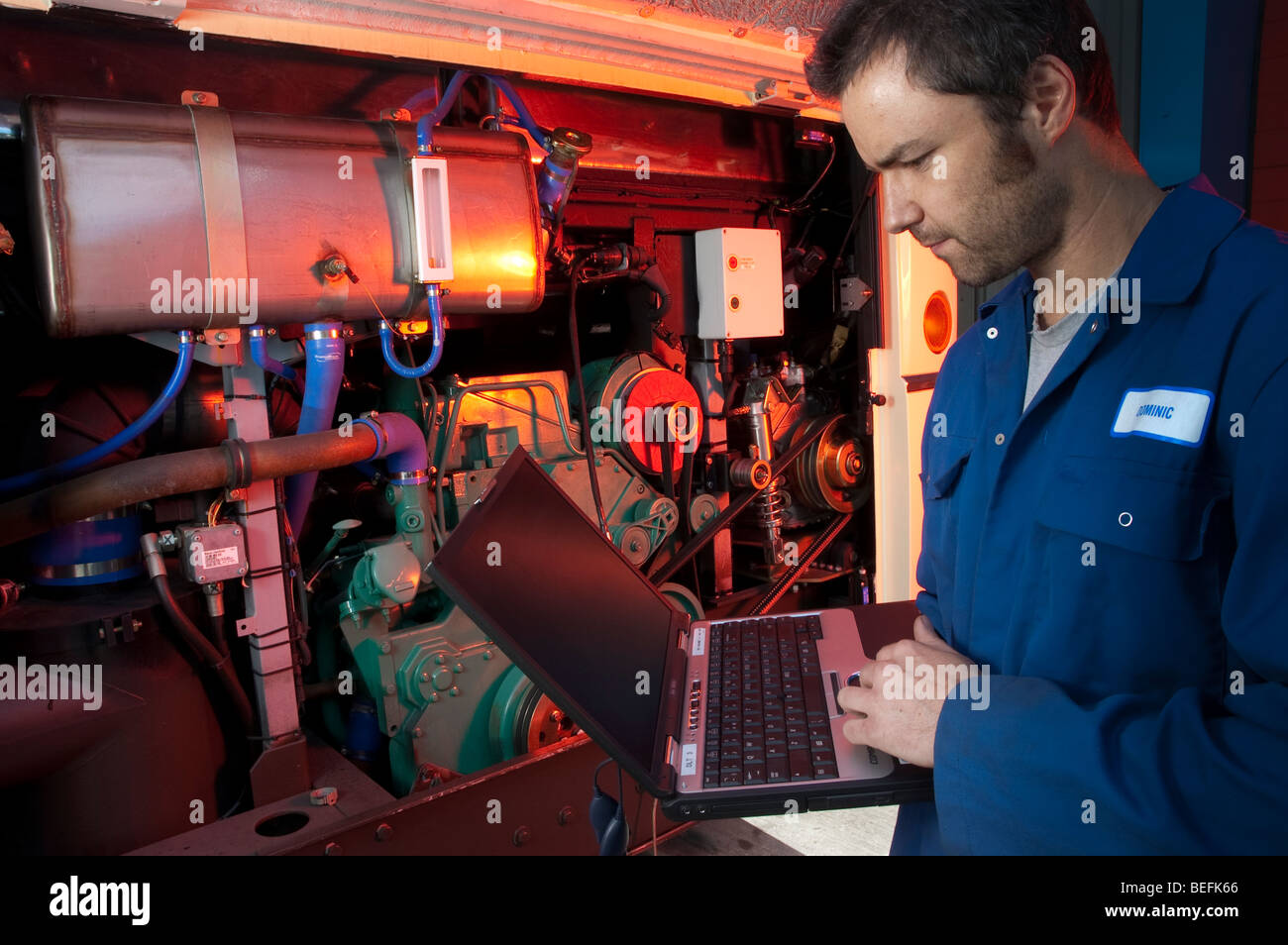 Motor mechanic using computer to set up and diagnose a coach engine ...