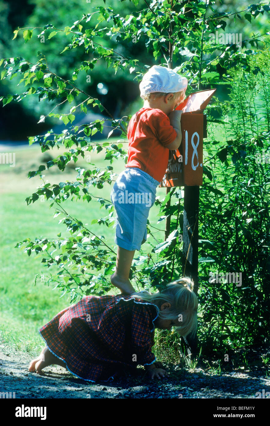 Children using the buddy system at rural mailbox on country road in ...