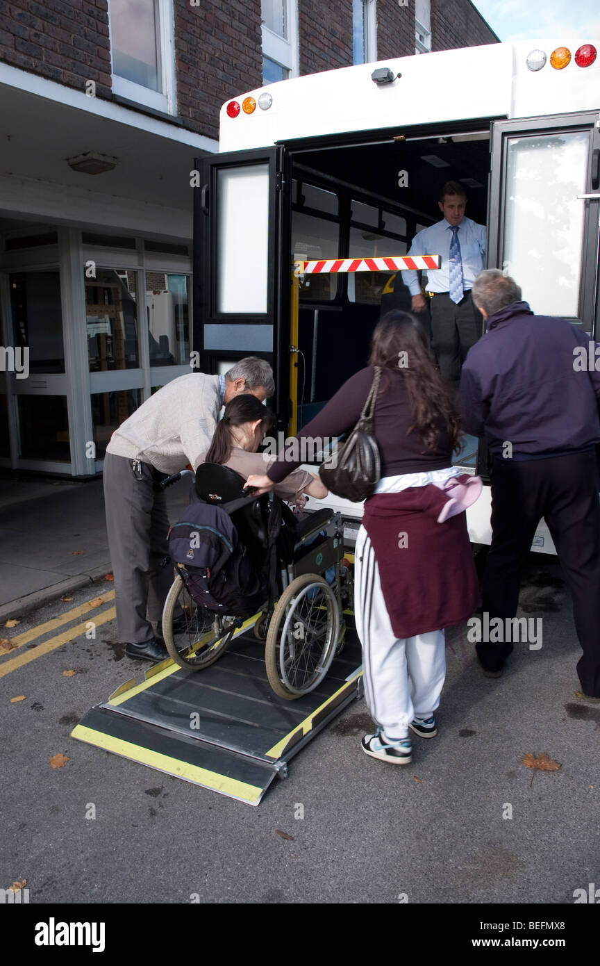 Loading a disabled person in a wheelchair into the rear entrance of a ...