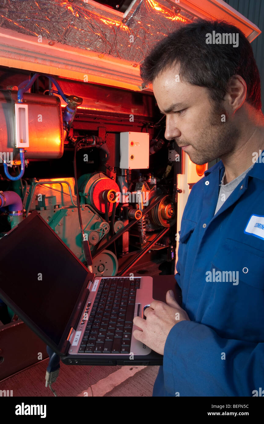 Motor mechanic using computer to set up and diagnose a coach engine ...